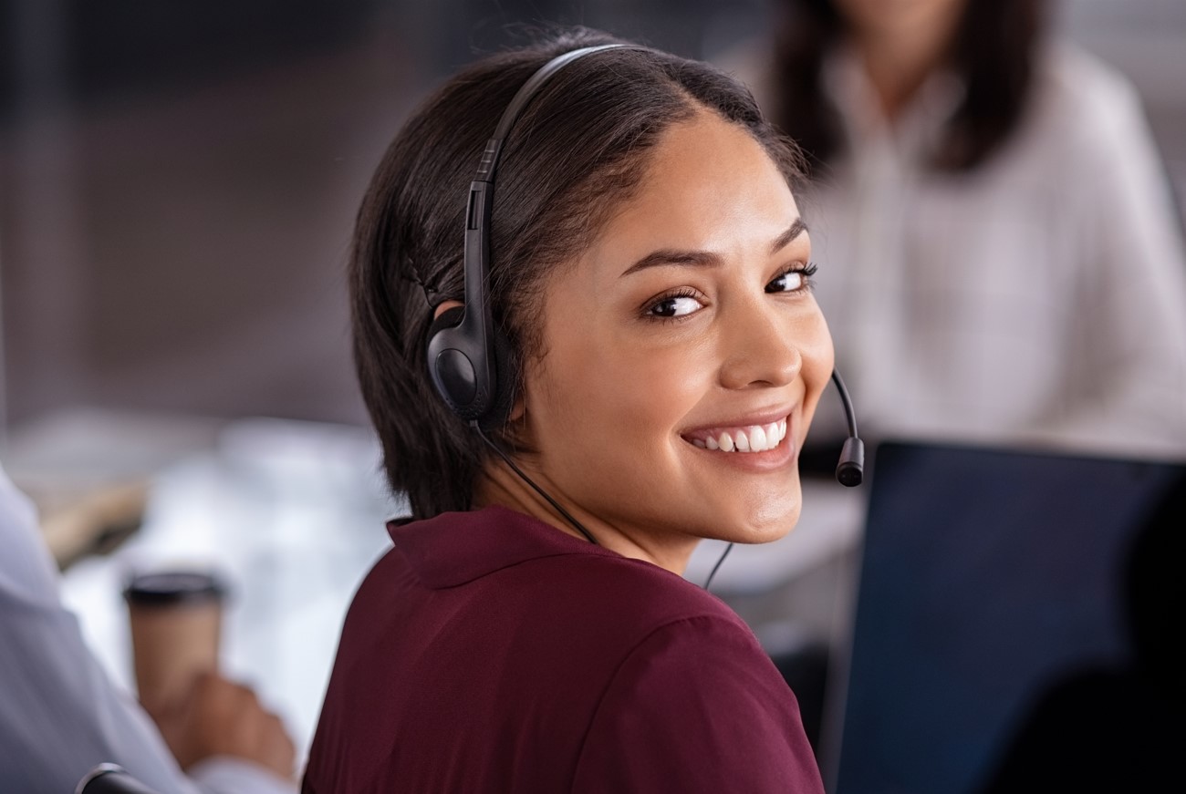 Closeup of a black woman working in a call center wearing a headset ...