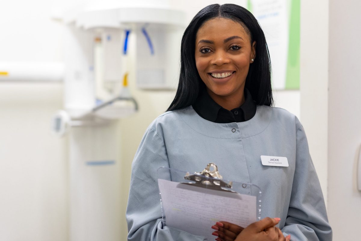 Black female PDS Health team member with braces smiling at the camera
