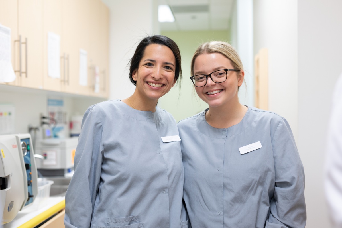 Two female PDS Health team members in a dentist’s office smiling at the ...